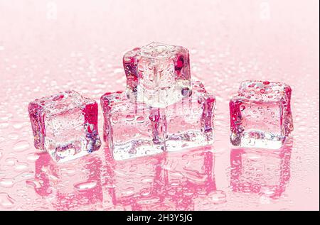 Fozen ice cubes on wet pink background Stock Photo - Alamy