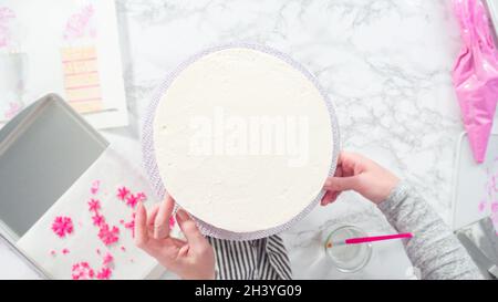Flat lay. Step by step. Decorating round funfetti cake with pink and ...