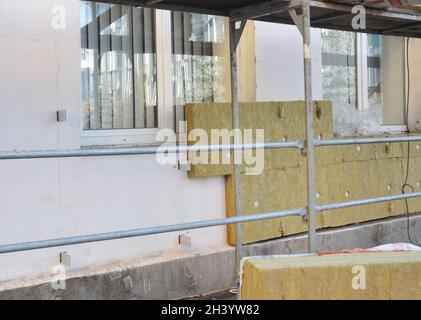 Installing mineral rock wool insulation to walls during new ...