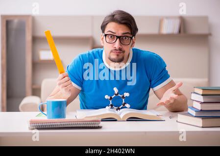 Male student with book and molecular model in library Stock Photo - Alamy