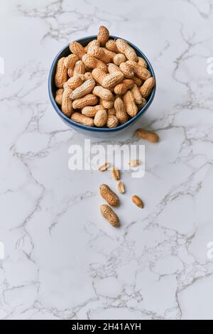 Image of bunch of peanuts in a bowl on a marble table Stock Photo - Alamy