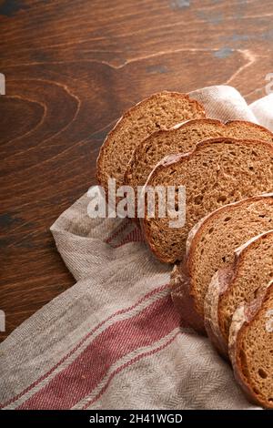 Traditional leavened sourdough bread cut into slice on a rustic wooden ...