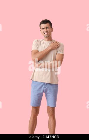 Young man scratching himself on light background Stock Photo - Alamy