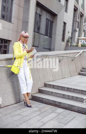 Female tapping on a cellphone at the railing Stock Photo - Alamy