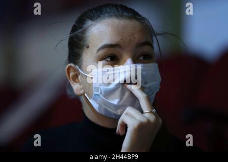 A tennis fan wearing face mask waits for the start of the semi final ...