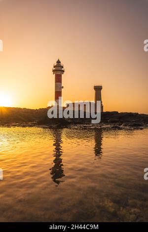 Vertical shot of the Toston Lighthouse at sunset in Punta Ballena ...