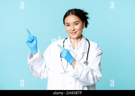 Smiling female doctor, physican in medical uniform and sterile gloves ...