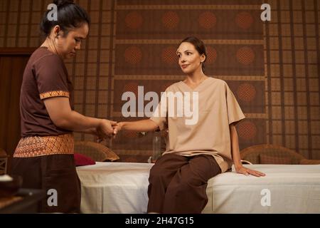 Massotherapist giving a hand massage to a female client Stock Photo - Alamy