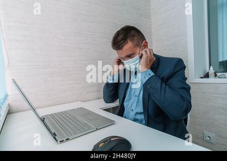 Viral threat, seasonal viral diseases. Man works in the office in a ...