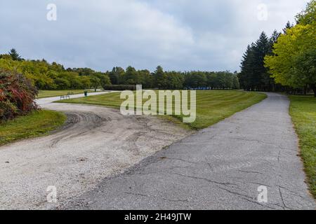 Long asphalt path in Citadel park with trees and lamps around next to ...