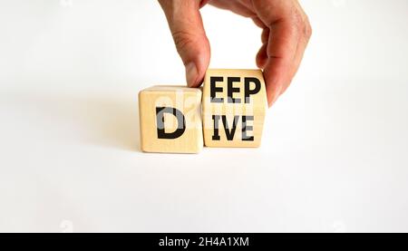 Deep dive symbol. Businessman turns a wooden cube with words 'Deep dive ...