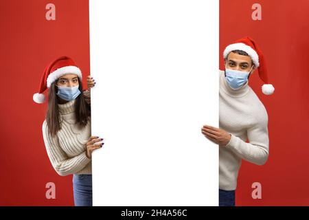 Xmas Offer. Excited Young Arab Couple In Santa Hats Demonstrating Blank ...
