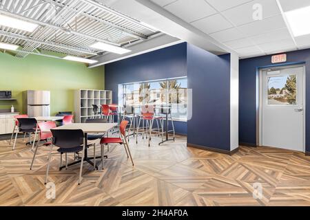 A colorful office break room with a hardwood floor, colorful chairs ...