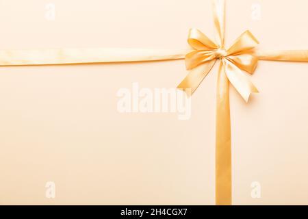 Top view of gold ribbon rolled and yellowbow isolated on colored ...