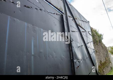 Old wobbly black metal gate with holes Stock Photo - Alamy