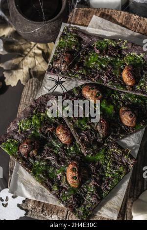 Halloween concept food. Flatbread or pizza with squid Ink, green cheese ...