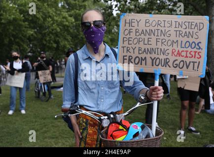 A protester holds a placard during the Trans march. Spectators ...