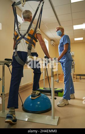 Rehabilitation room with parallel bars and equipment for physical ...