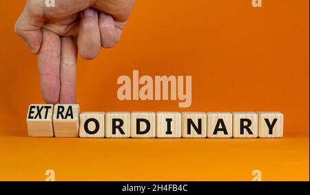 Ordinary or extraordinary symbol. Businessman turnes wooden cubes and ...