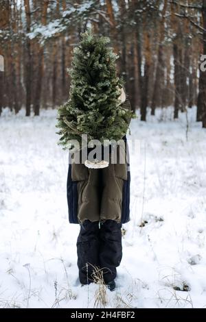 Faceless woman in santa hat lying on bed at home with laptop and ...