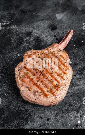 BBQ Grilled Tomahawk beef veal steak on butcher table. Black background ...
