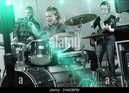 Rehearsal of music group with female drummer Stock Photo - Alamy