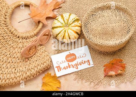 Sunglasses, wicker bag, hat, pumpkin, dry leaves and paper card with ...