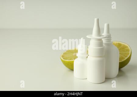 Blank bottles of nasal spray and lime halves on white table Stock Photo ...