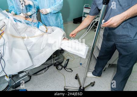 The doctor injects anesthesia with a syringe into the arm of a patient ...