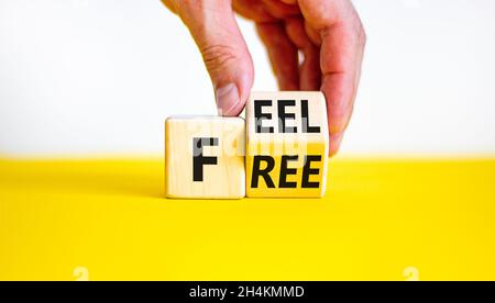 Feel free symbol. Businessman turns a wooden cube with concept words ...