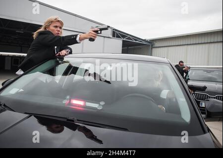Professional armed team of female and male bodyguards shoot and protect ...