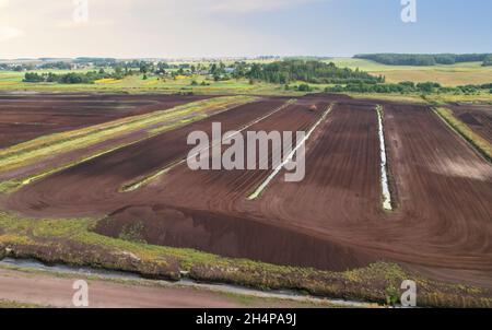 Peat extraction site. Harvester at collecting peat on peatlands. Mining ...