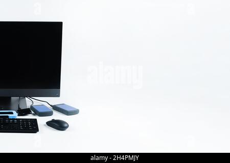 Multiple external hard drives connected to a monoblock on a white ...