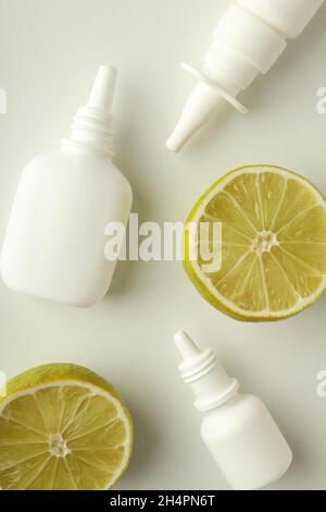 Blank bottles of nasal spray and lime halves on white table Stock Photo ...