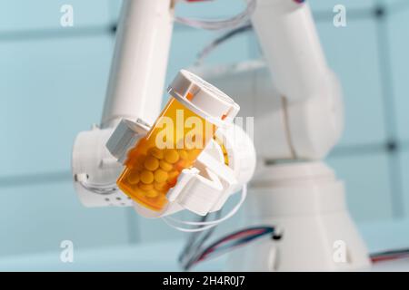 Robot arm with a pills in bottle in the laboratory. The concept of ...