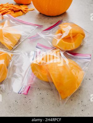 Fresh raw peeled pumpkin slices in zip lock bags close up, ready to be ...