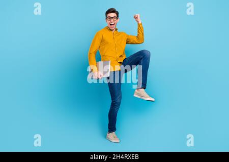 Photo of champion guy hold netbook rejoice scream wear white t-shirt ...