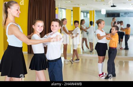 Teacher is demonstrating to children how to dance tango Stock Photo - Alamy