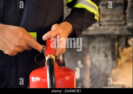 Hand pulling pin of fire extinguisher. Safety concept Stock Photo - Alamy