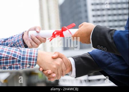Shaking hands, graduation and certificate for college student with ...