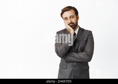 Sad and bored man lean face on hand, looking at camera empty-headed ...