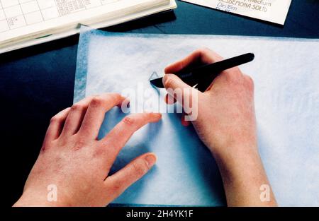 Graphic designer using Letraset, dry transfer lettering system in the ...