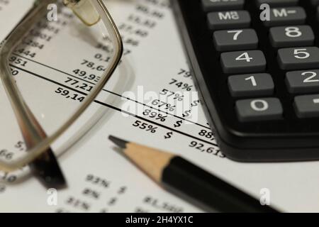Financial report, calculator, pencil and glasses on the table in the ...