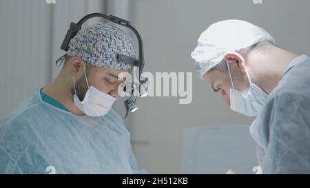 Surgeons perform bloody operation. Action. Two professional surgeons ...