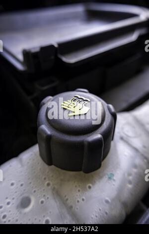 coolant system reservoir cap with warning and manual signs in a car ...