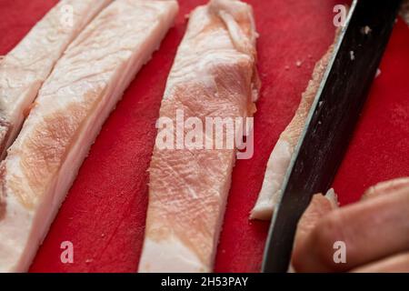 Butcher cutting little pieces of fat pork meat Stock Photo - Alamy