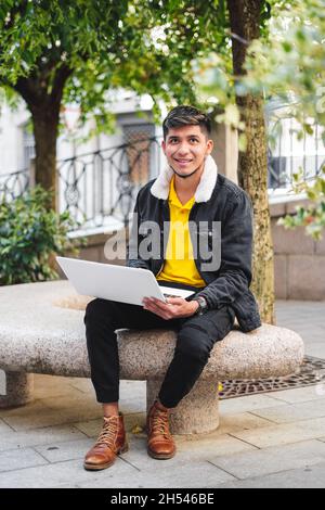 Spanish student working outdoors sitting on the grass with laptop Stock ...