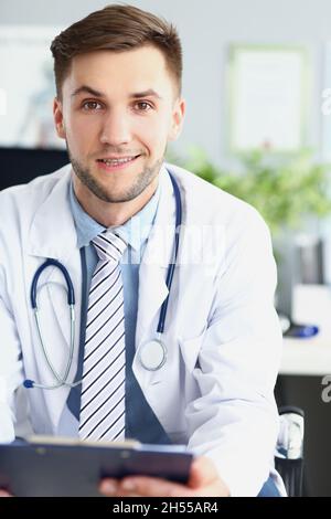Ready for a checkup. A young smiling doctor holding her stethoscope up ...
