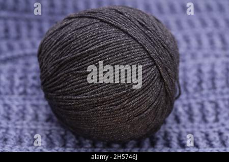 a black ball of wool lies on a white woolen tablecloth. High quality ...