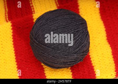 a black ball of wool lies on a white woolen tablecloth. High quality ...